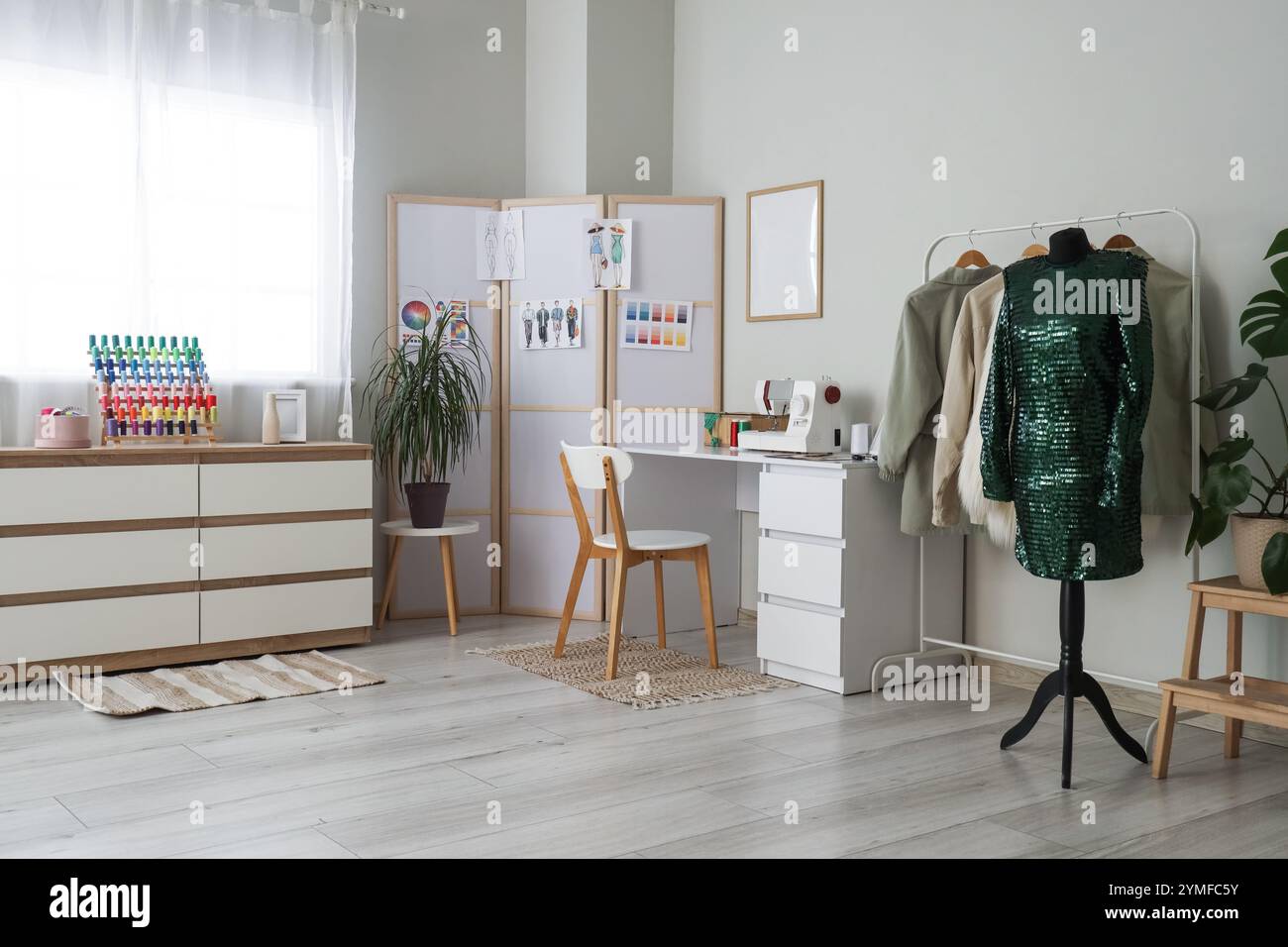 Interior of atelier with tailor's workplace, folding screen and drawers ...