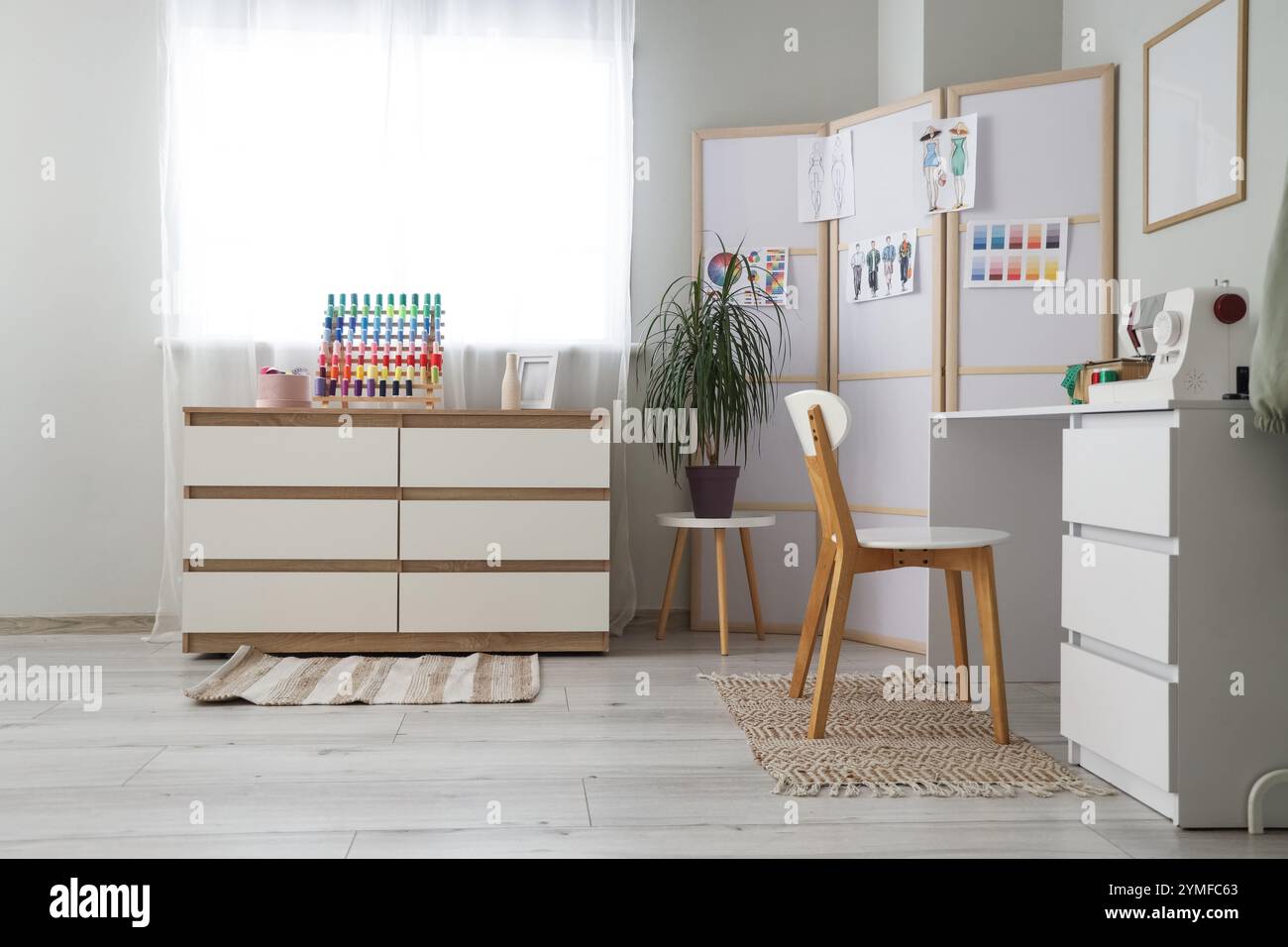 Interior of atelier with tailor's workplace, folding screen and drawers ...