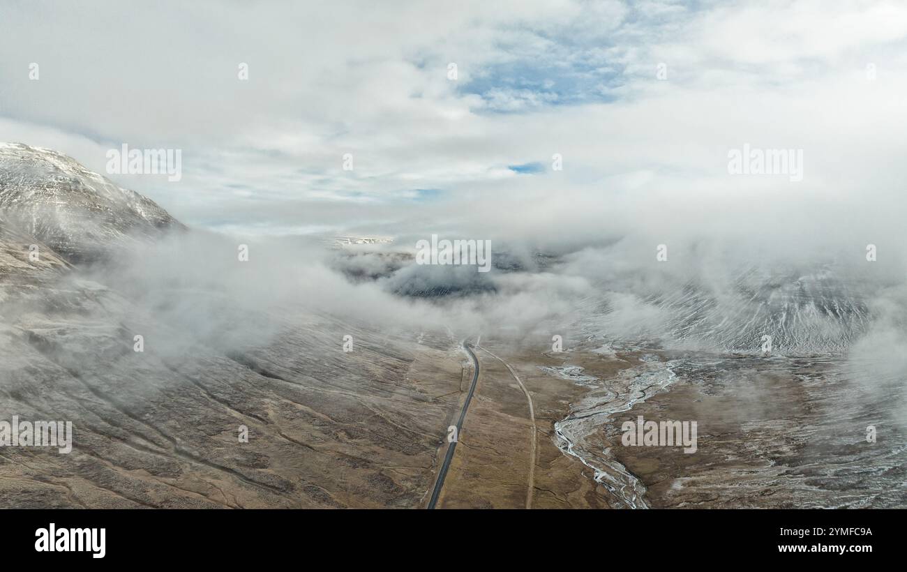 Foggy drone view of road through canyon of volcanic swamps with frozen ...
