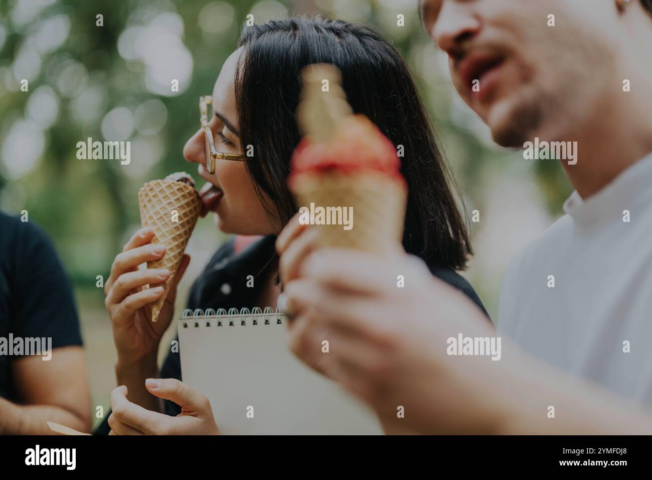 Students enjoying an ice cream break with professor outdoors Stock ...