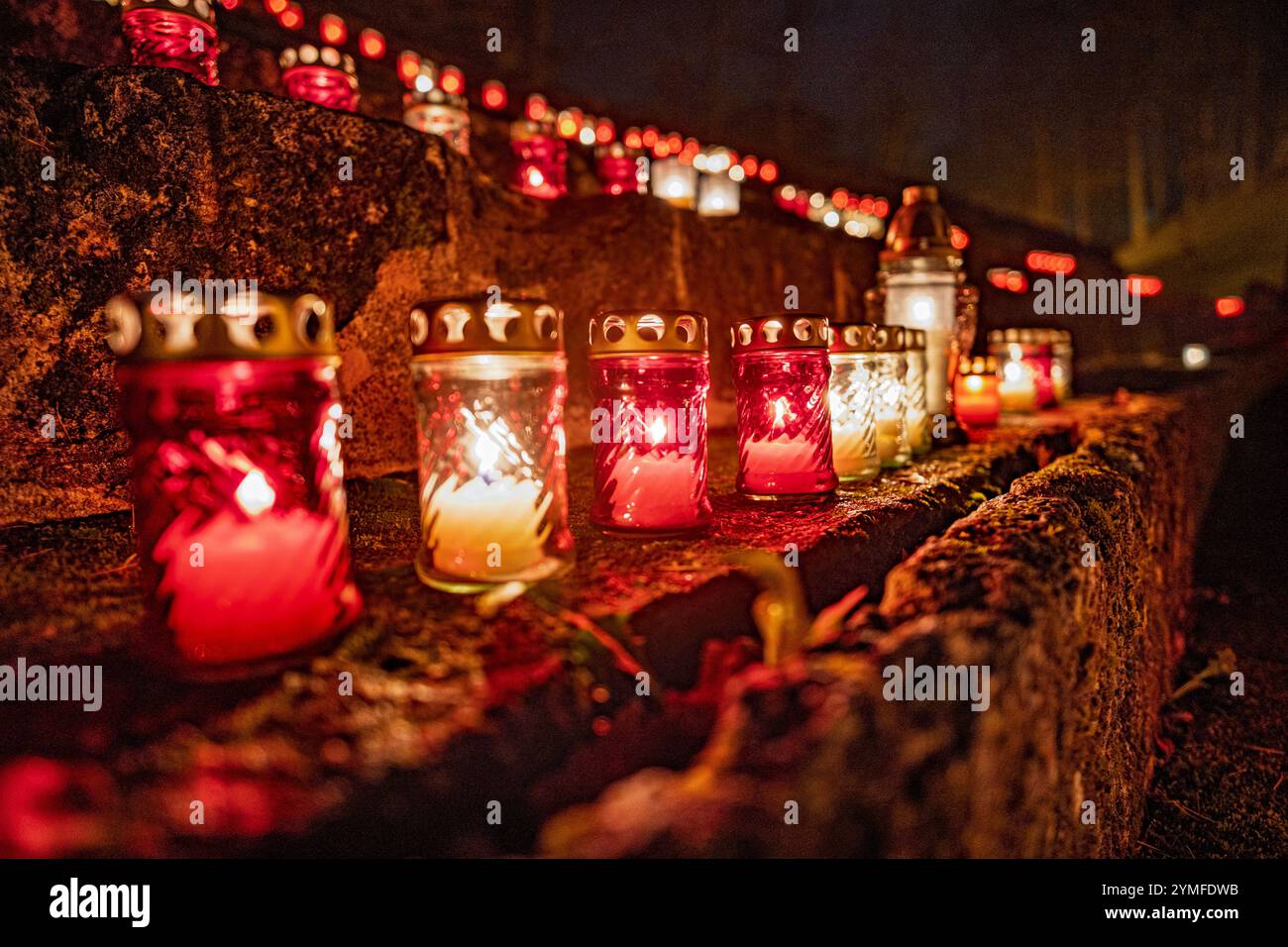 Glowing red and white candles arranged on stone steps at night ...