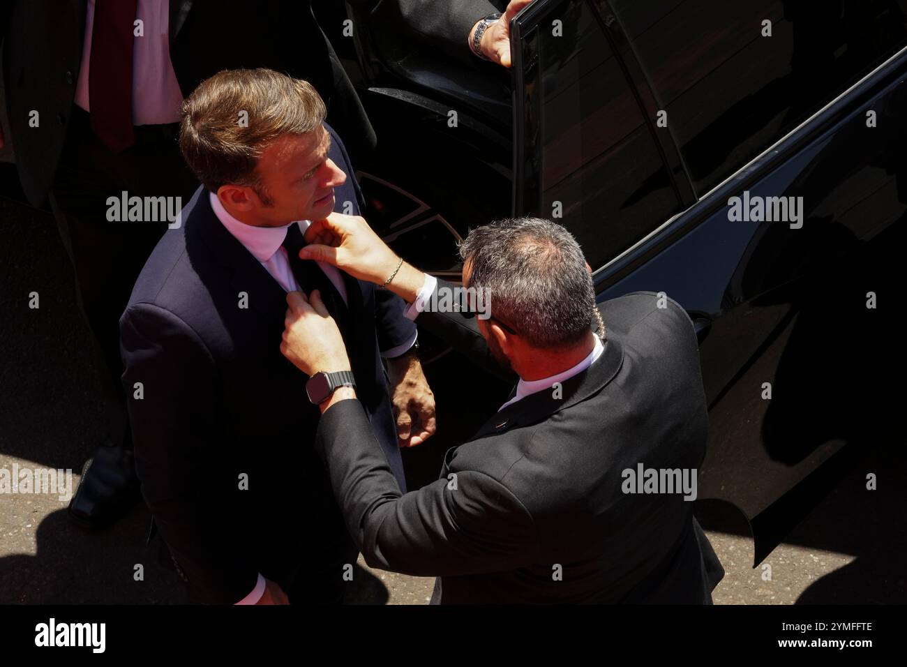 French President Emmanuel Macron stands still as a member of his ...