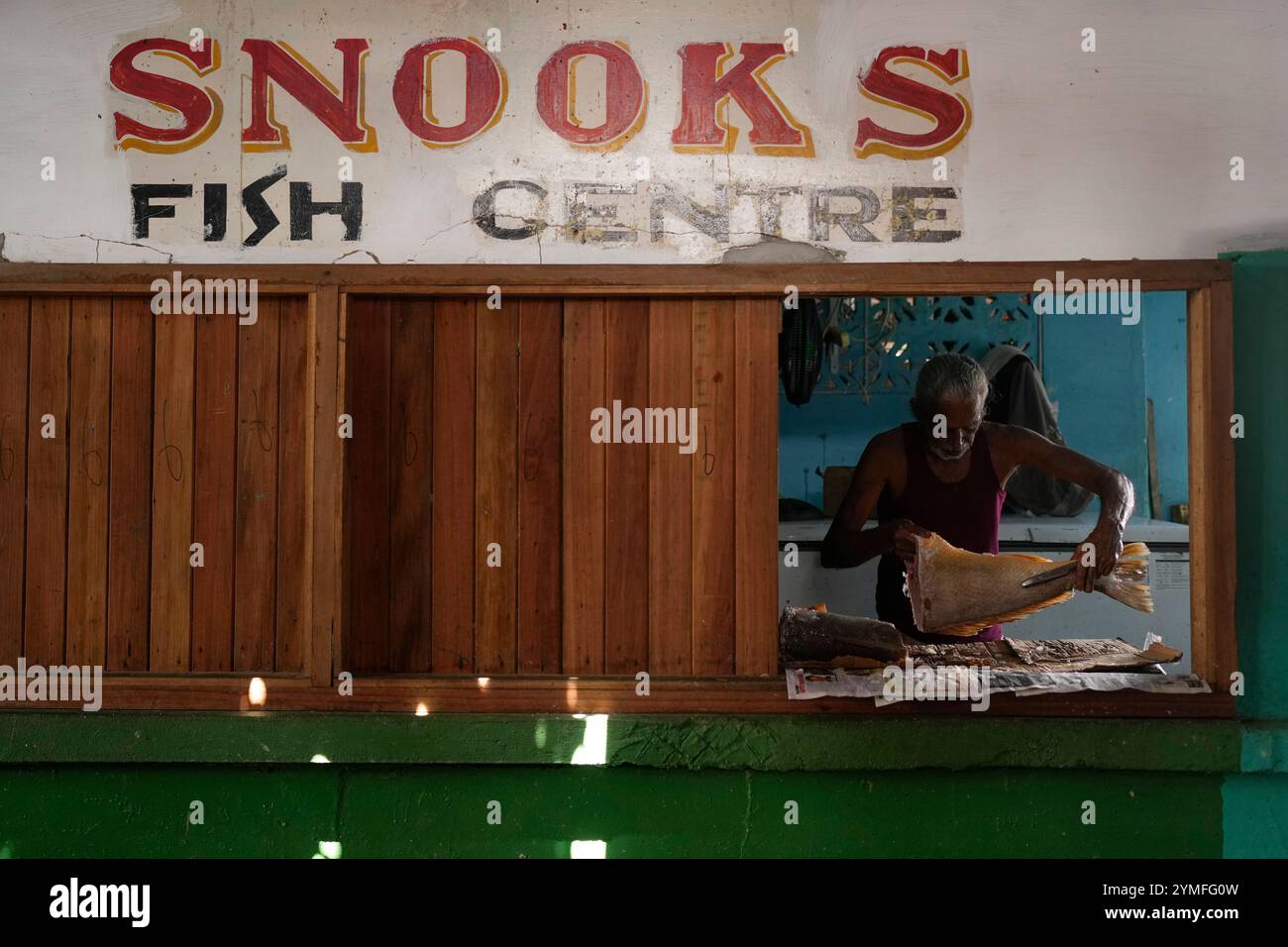 A fishmonger guts a fish at the Stabroek Market at the port of ...