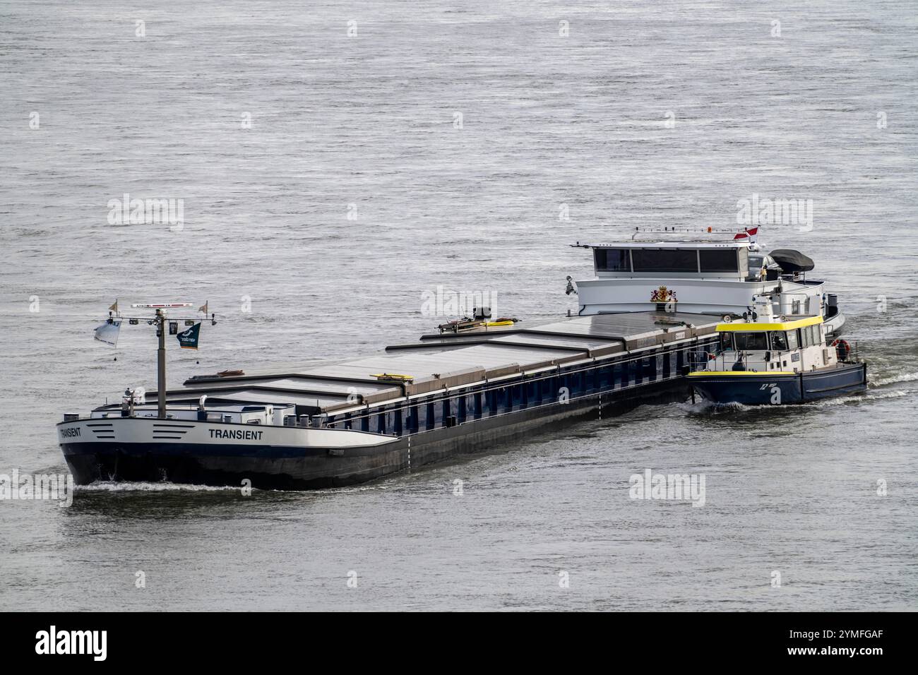 Water police boat sailing alongside a cargo ship on the Rhine near ...