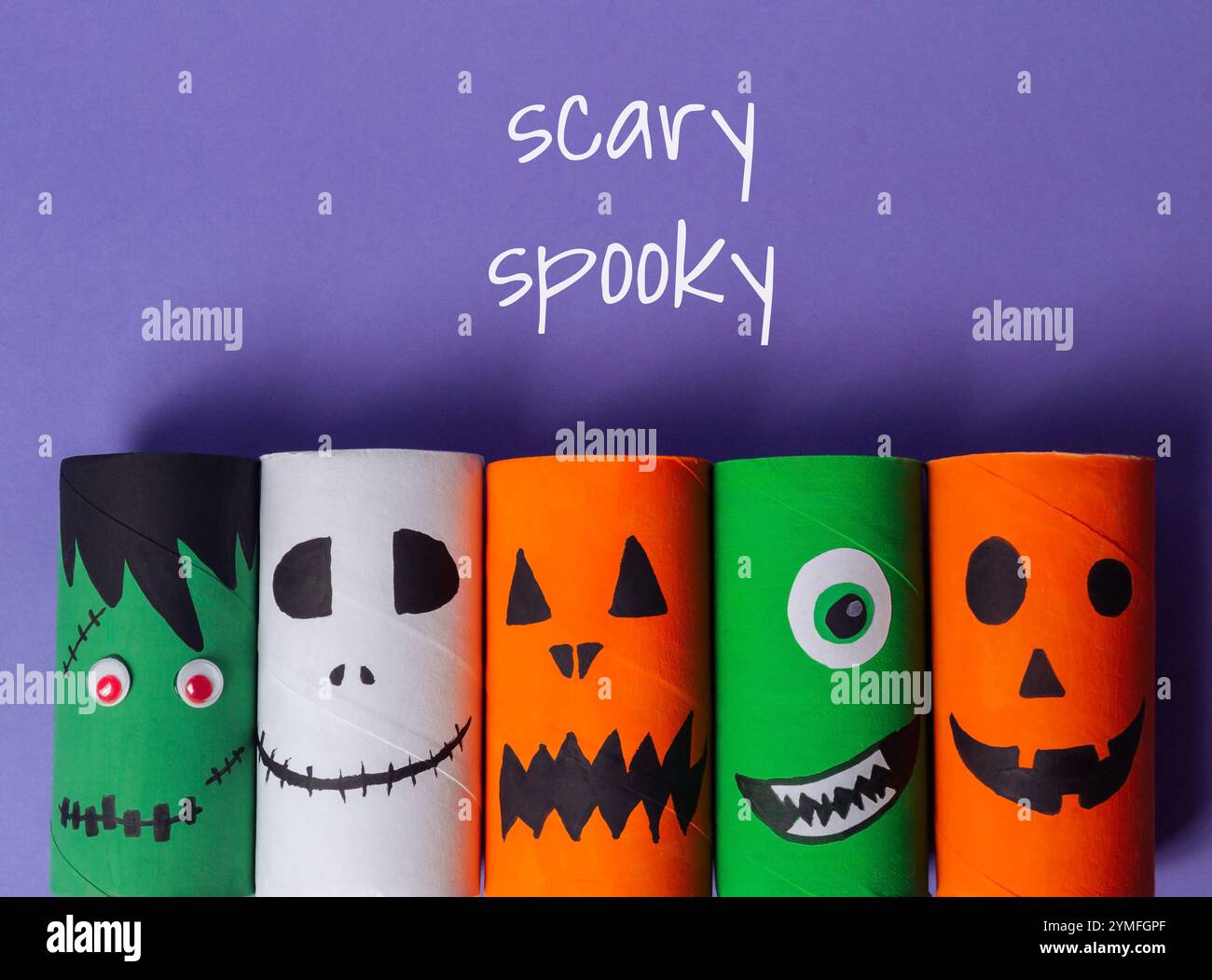 Group of paper tubes with scary faces on them. The tubes are lined up ...