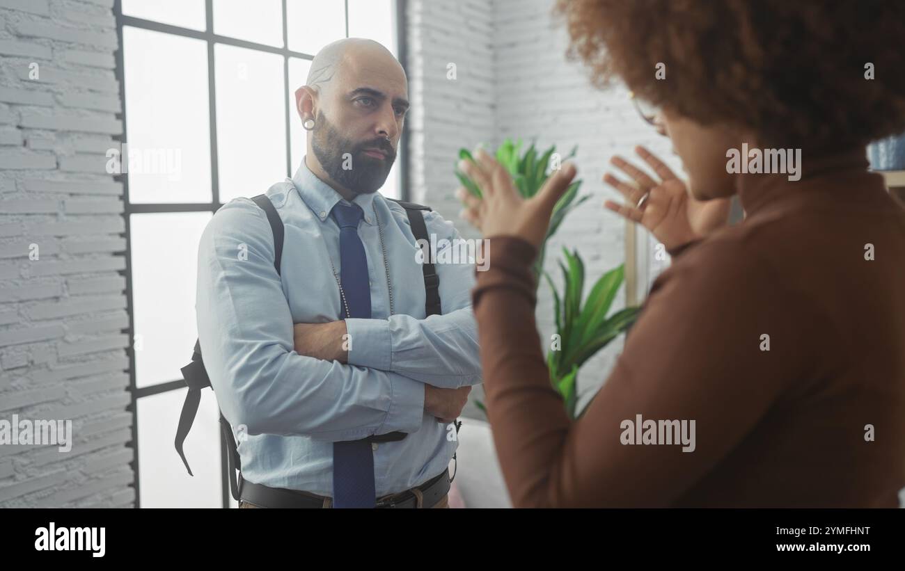 A bald man and an african american woman engaged in a serious ...