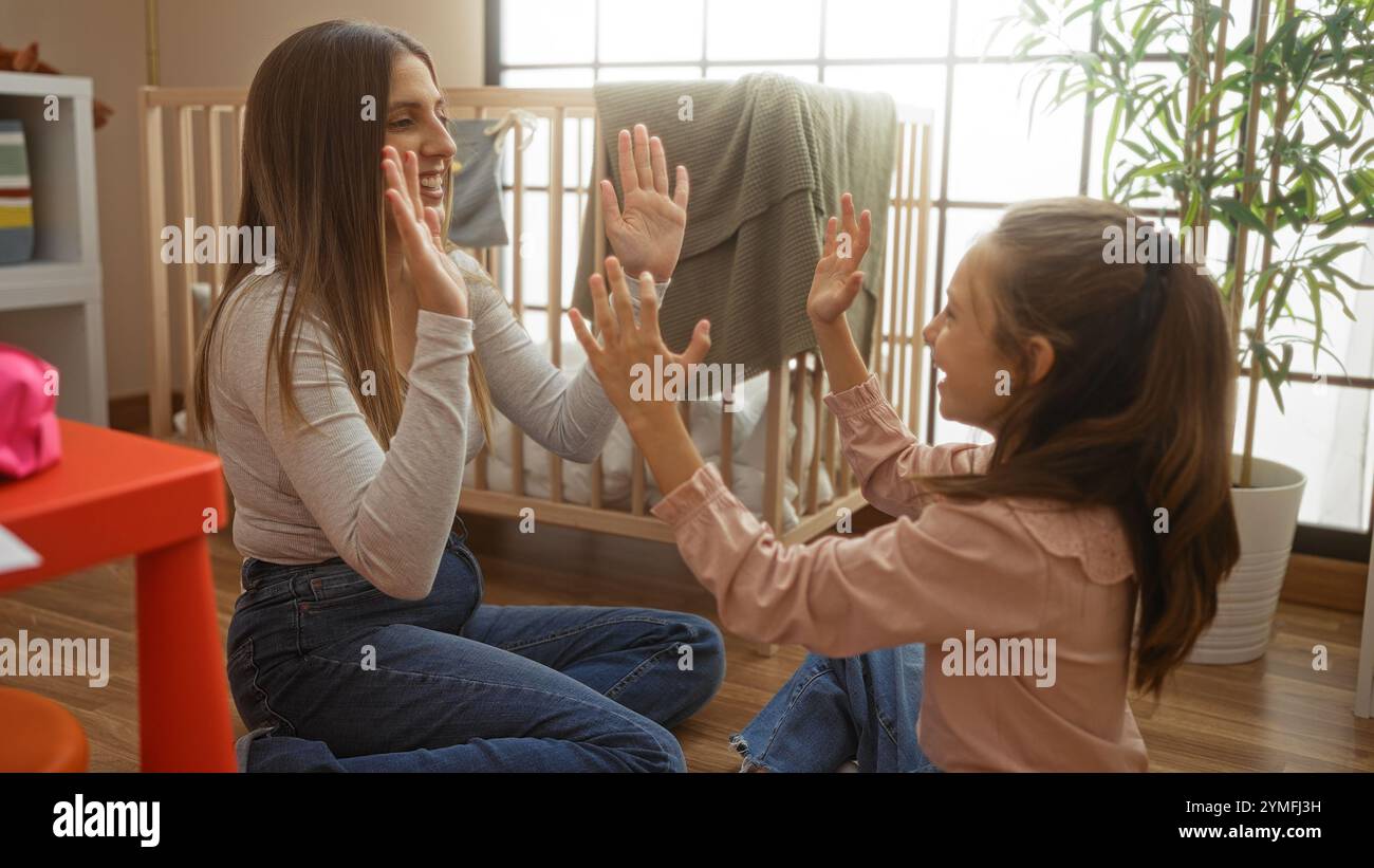 Mother and daughter playing clapping game on the floor in cozy bedroom showcasing family bond ...