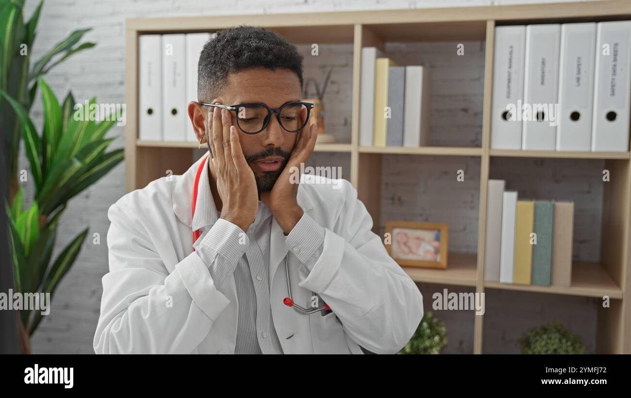 Stressed african american male doctor wearing glasses in a hospital ...
