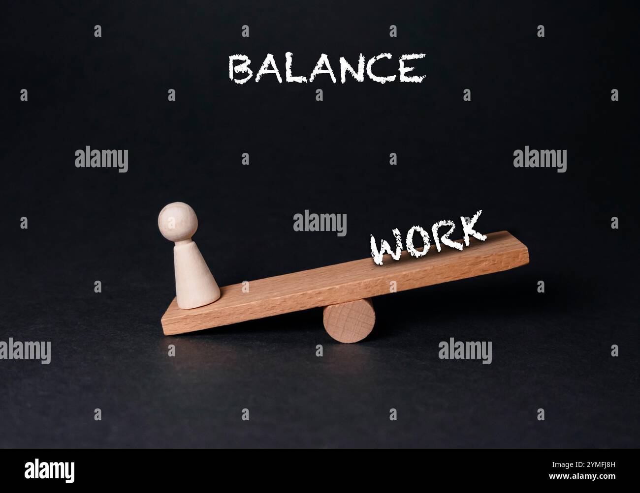 Wooden scale with a person on one side and the word balance on the ...