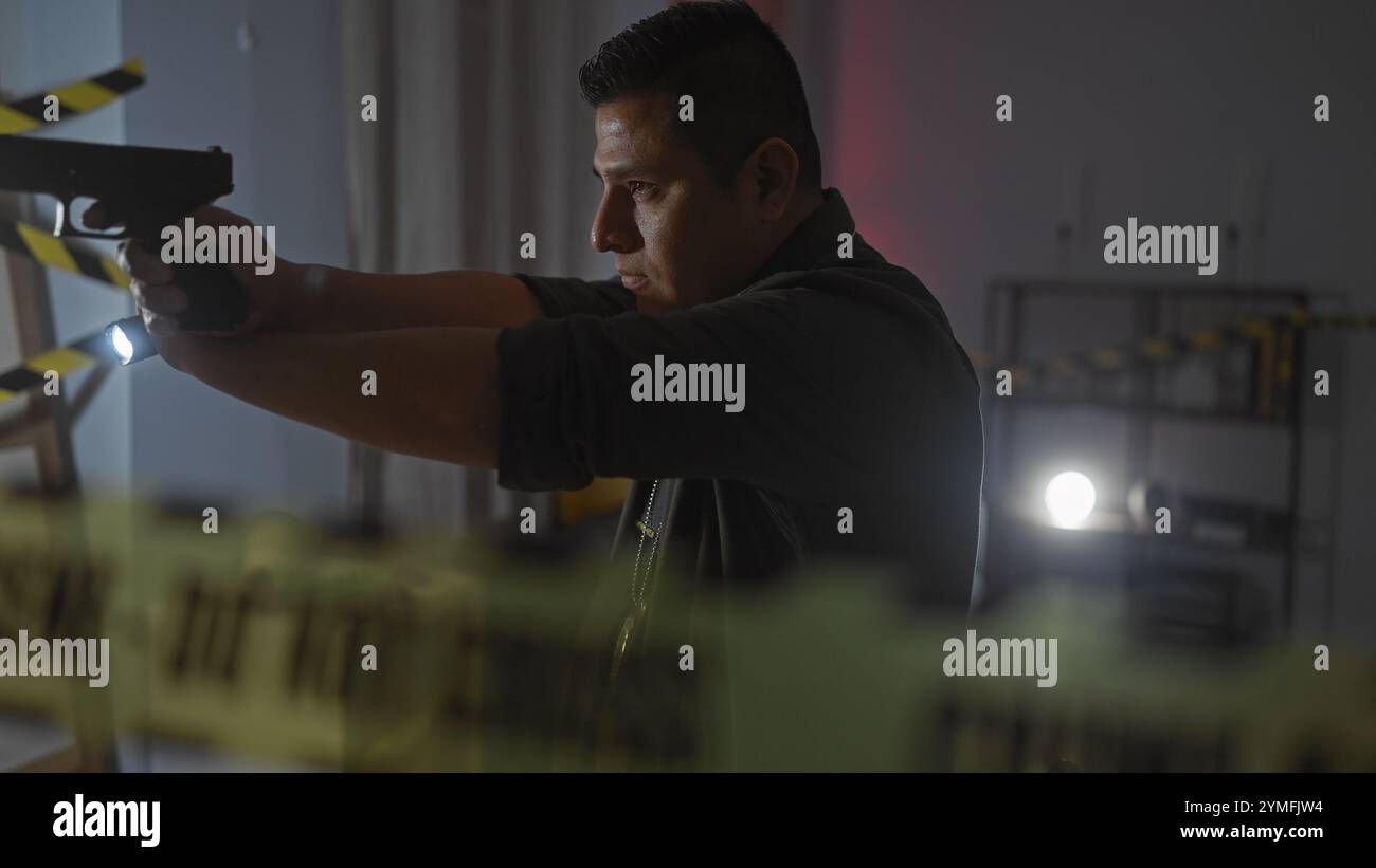 Hispanic man holding gun and flashlight in a dark indoor crime scene ...