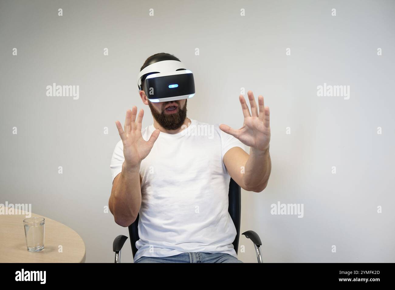 Man using hand gestures to interact with virtual environment while wearing VR headset Stock ...