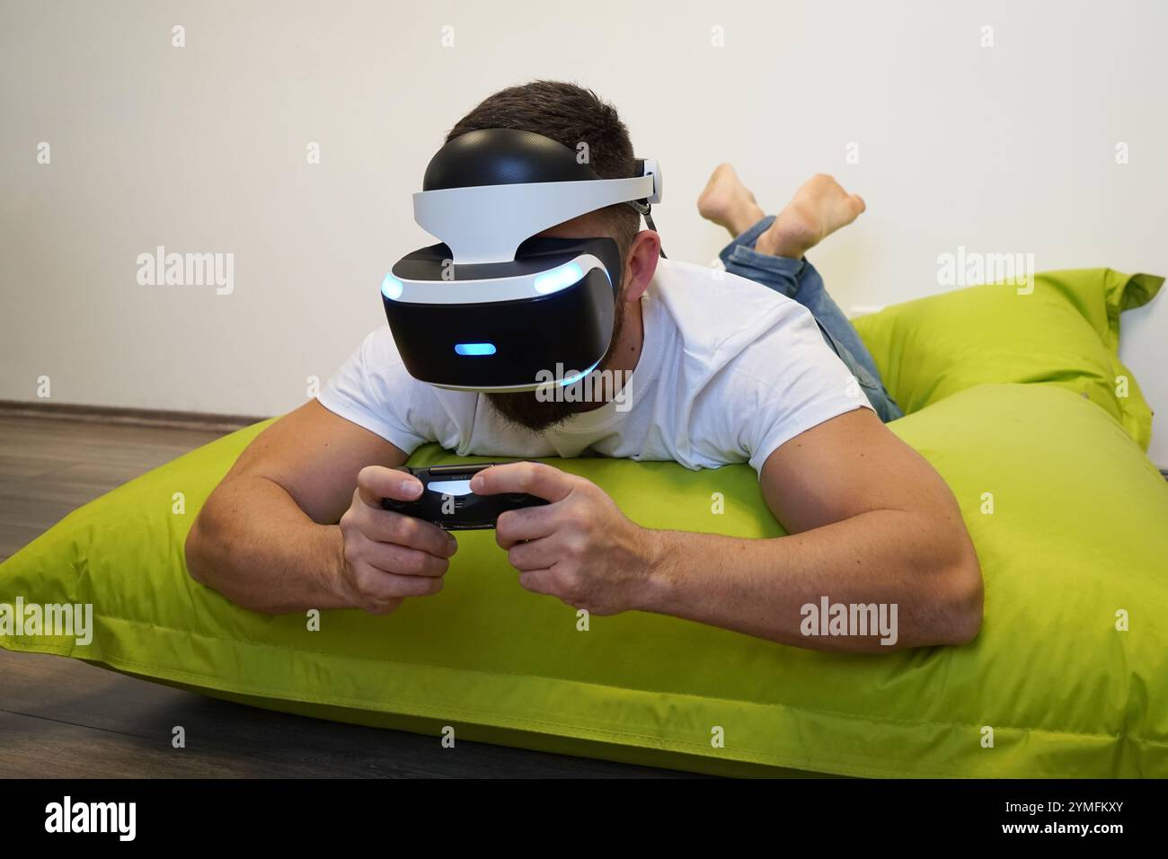 Man lying face down on green bean bag, fully immersed in VR gaming ...