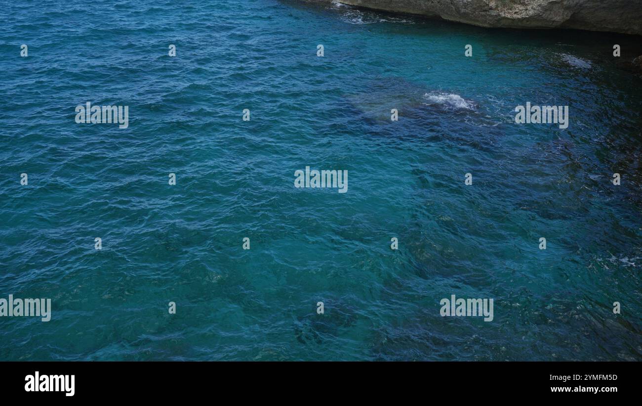 Aerial view of vibrant blue water at cave of poetry in salento, puglia ...