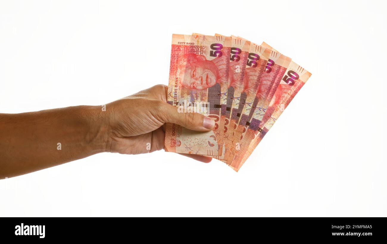 Hand holding south african rand banknotes against an isolated white ...