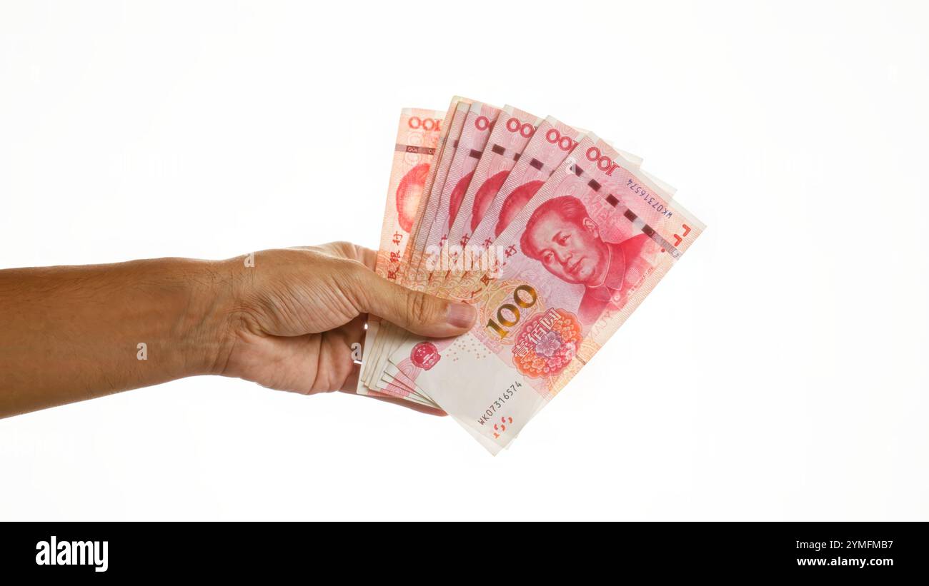 Hand holding a fanned-out stack of chinese yuan banknotes over isolated ...