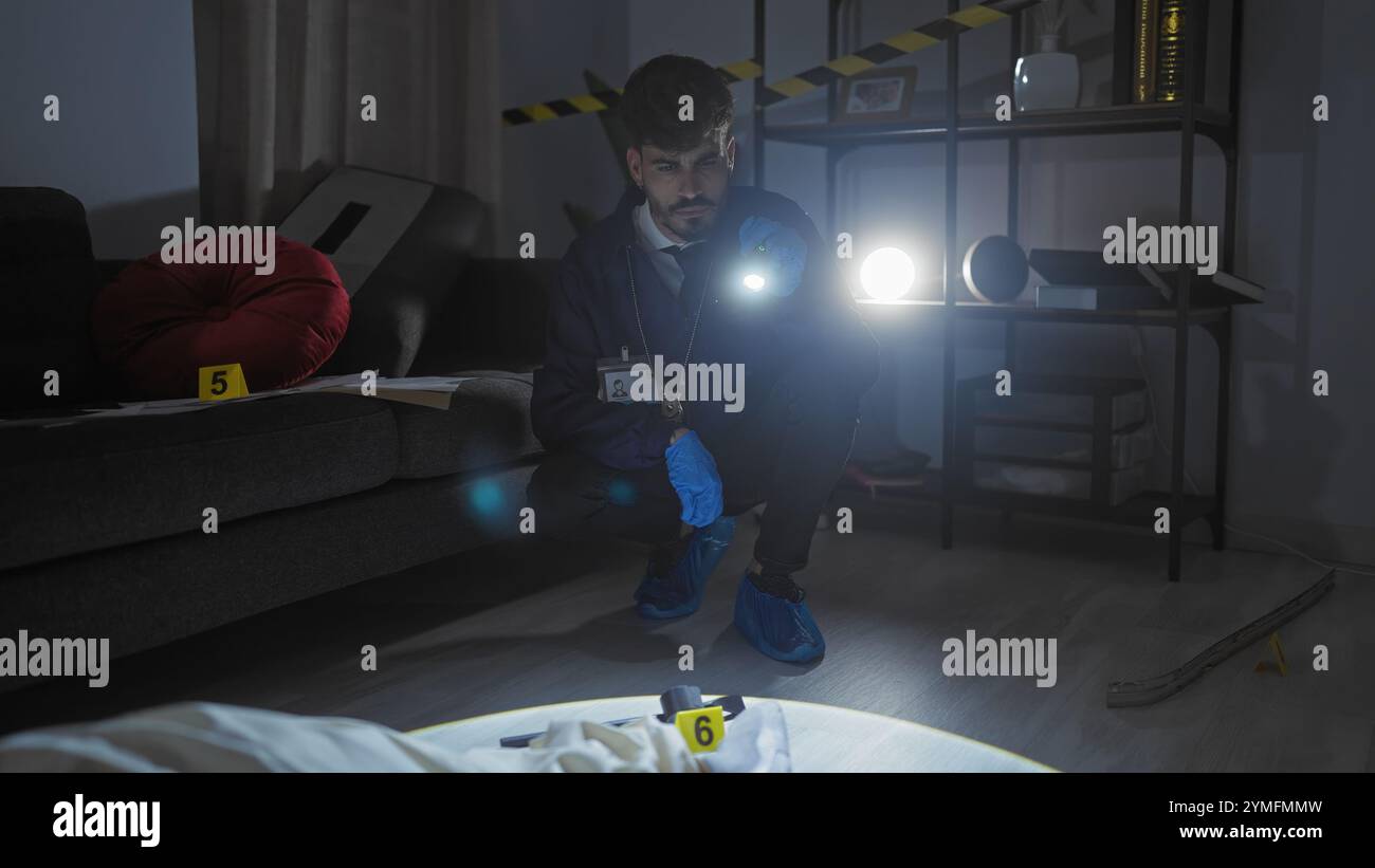 Handsome detective analyzes evidence at a dimly lit indoor crime scene ...