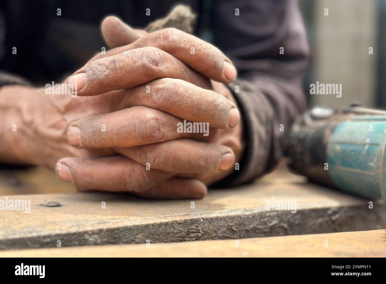 closeup of clasped rough dirty hands of elderly hard working carpenter ...