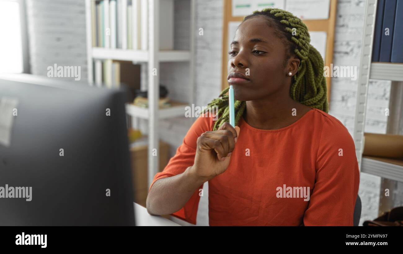 Woman thinking with pen at workplace, indoor office setting, wearing ...
