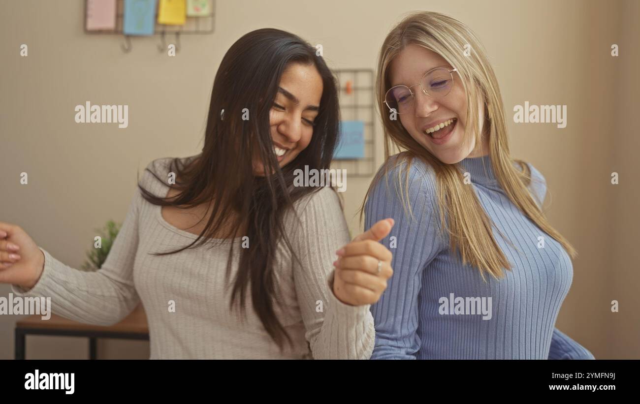 Two women laughing and dancing together in a cozy living room ...