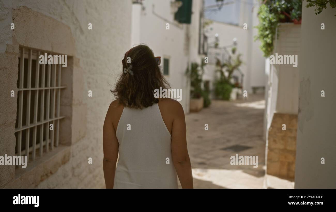 A young hispanic woman strolls through the charming old town streets of ...