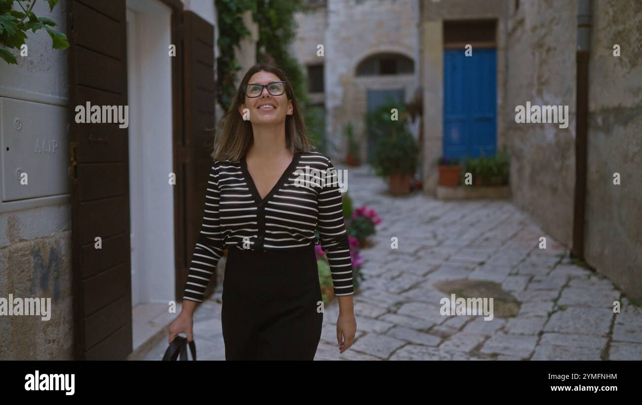 A beautiful young hispanic woman walking through the charming ...