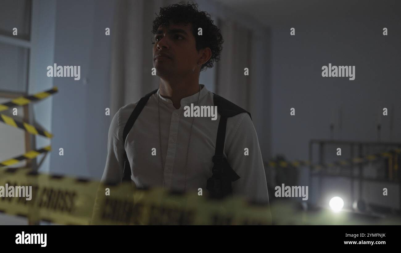 Hispanic man in suspenders pondering at a dimly-lit crime scene in a ...