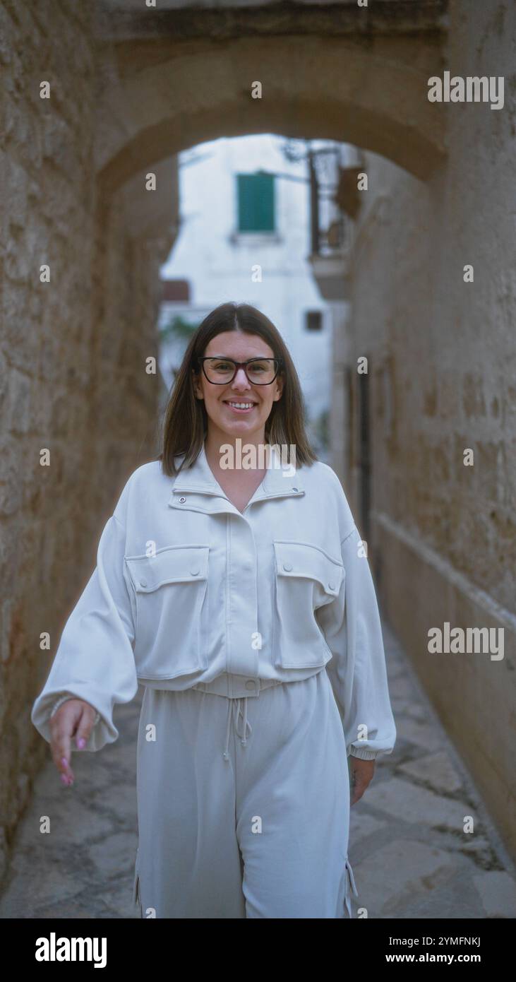 A young, beautiful hispanic woman walks through the charming streets of ...
