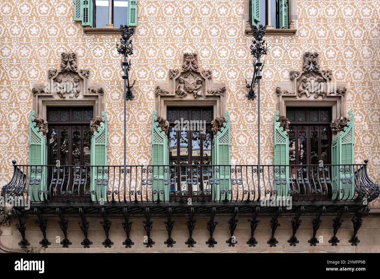Balcony with cast iron rail, three rectangular windows with open green ...