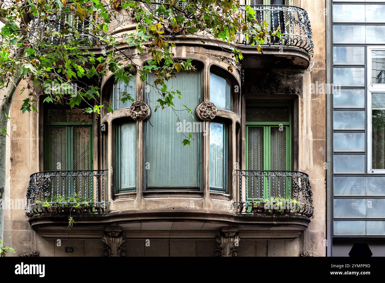 Large alcove window with two balconies on both sides against a beige ...