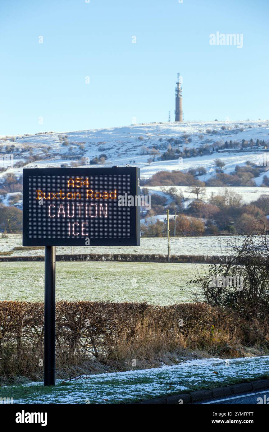 Digital road sign warning of ice on the A54 Buxton road during a snow ...