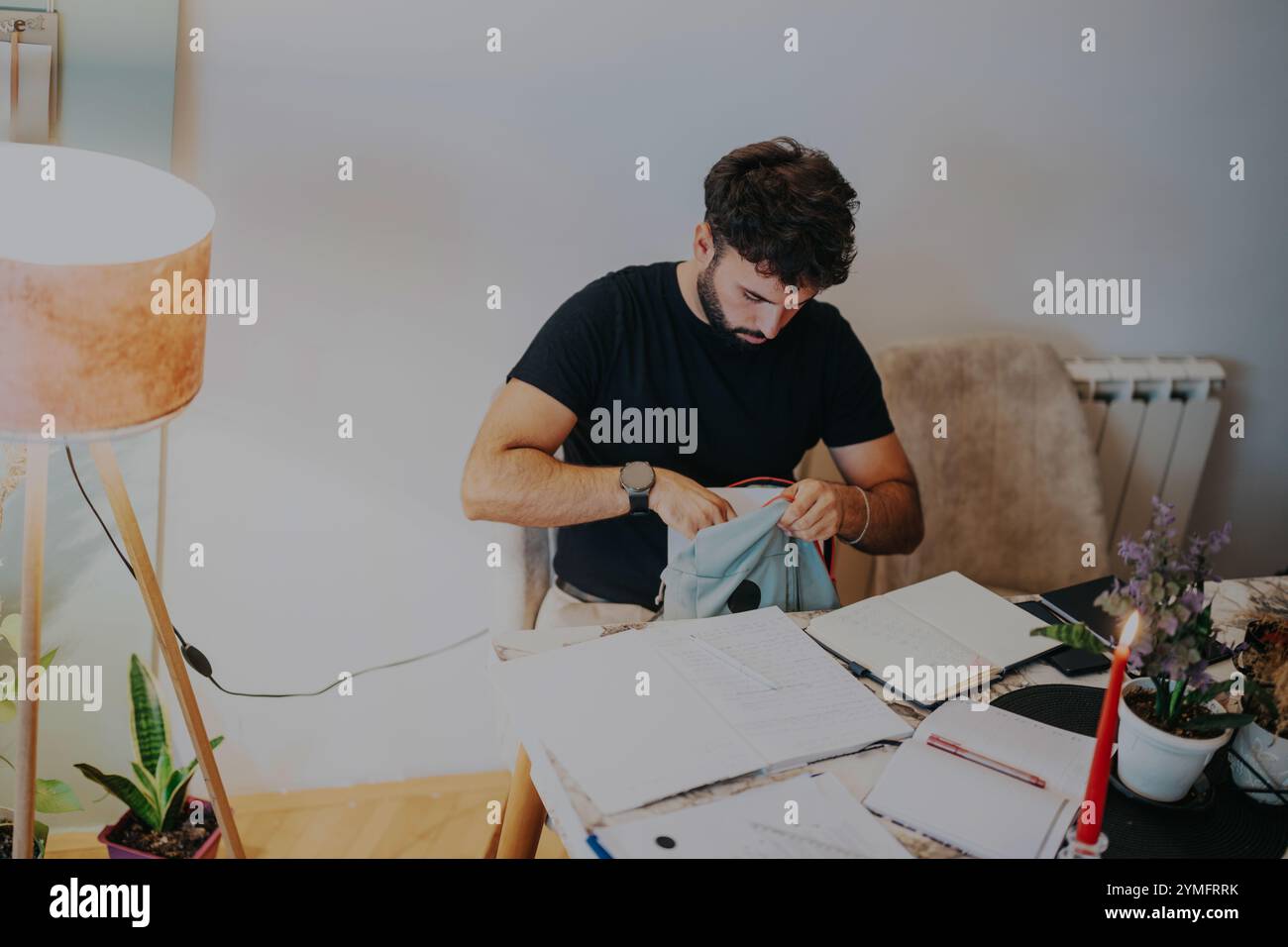 College student organizing study materials at home workspace Stock ...