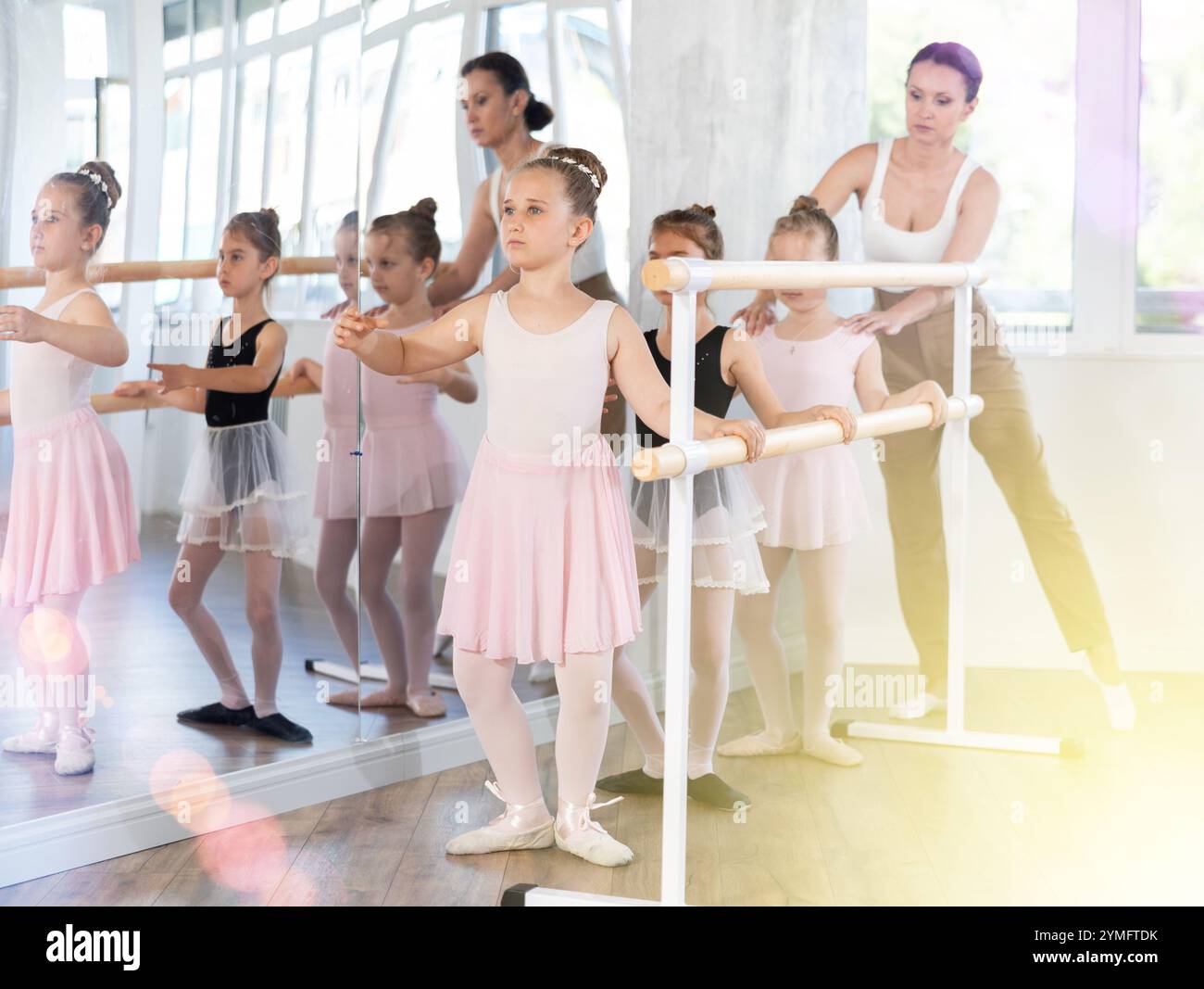 Woman teacher corrects girls in plie movement Stock Photo - Alamy