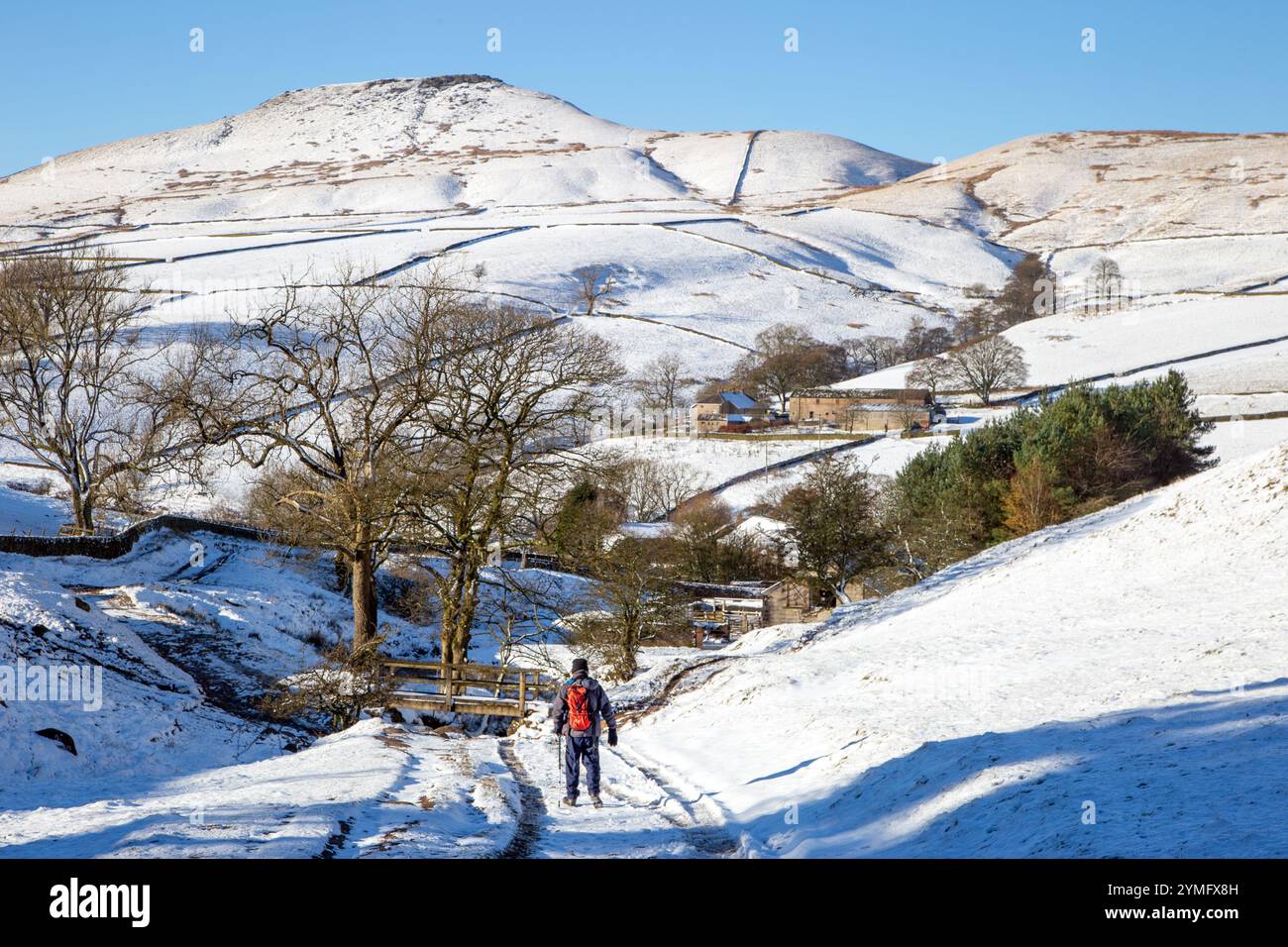 Man walking alone backpacking in a snow covered Cheshire Peak District ...