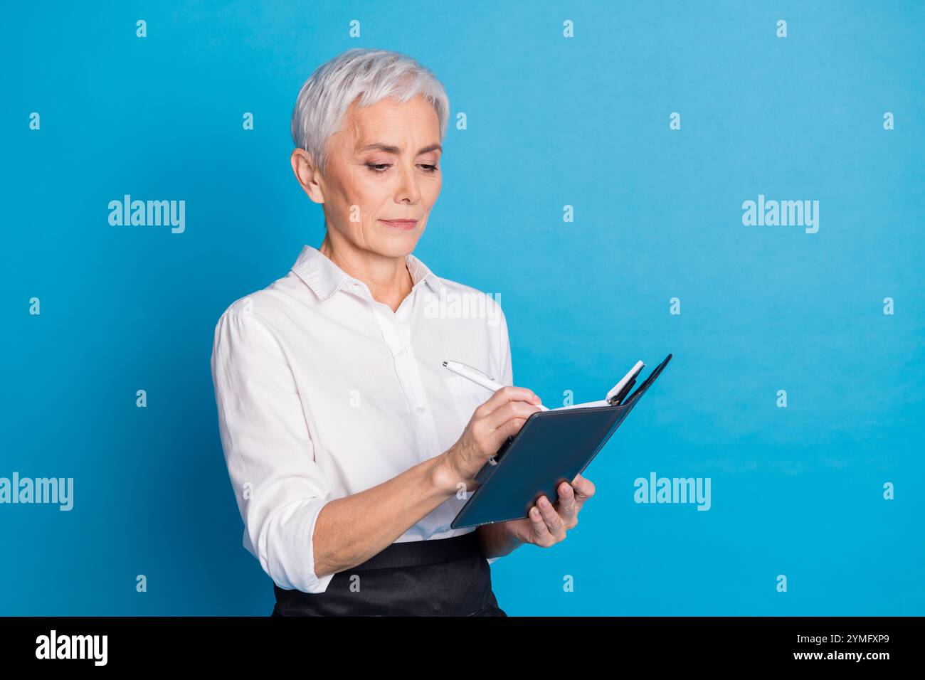 Photo of attractive senior woman write order notebook small business ...