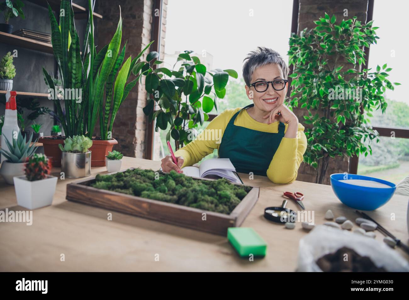 Photo of nice elderly lady write notebook planning wear green apron ...