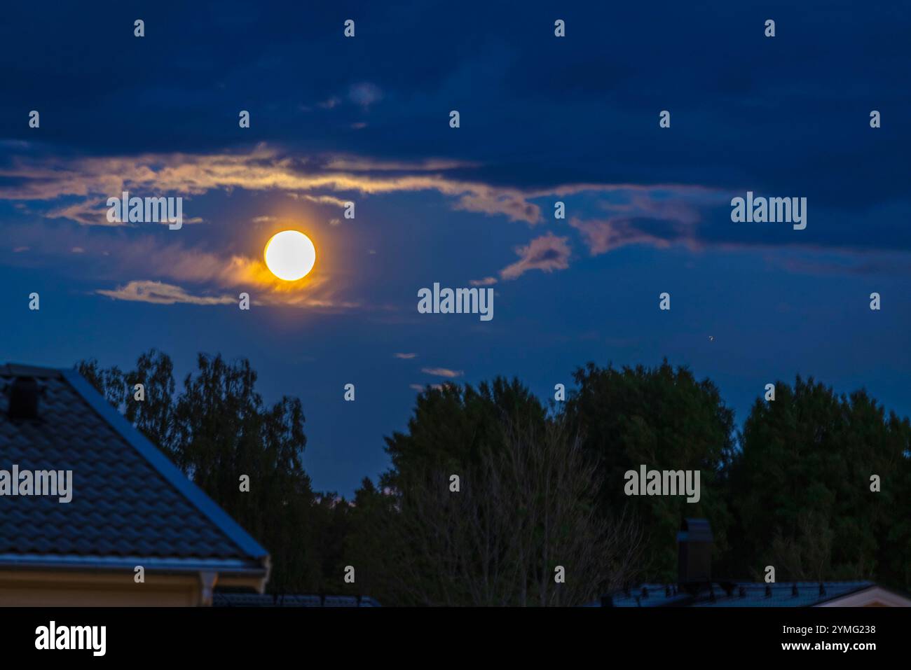 Full moon illuminating dark night sky with soft clouds and silhouettes ...