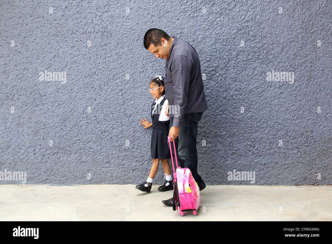 Divorced single dad walks to school with his 4 year old brunette daughter carrying her backpack ...