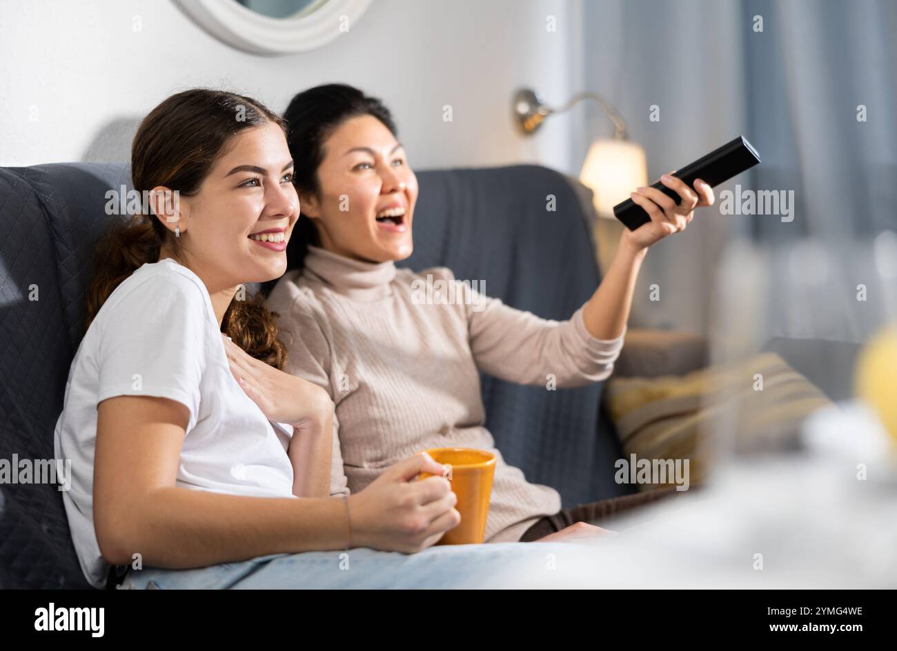 Two women relaxing at home watching TV Stock Photo - Alamy