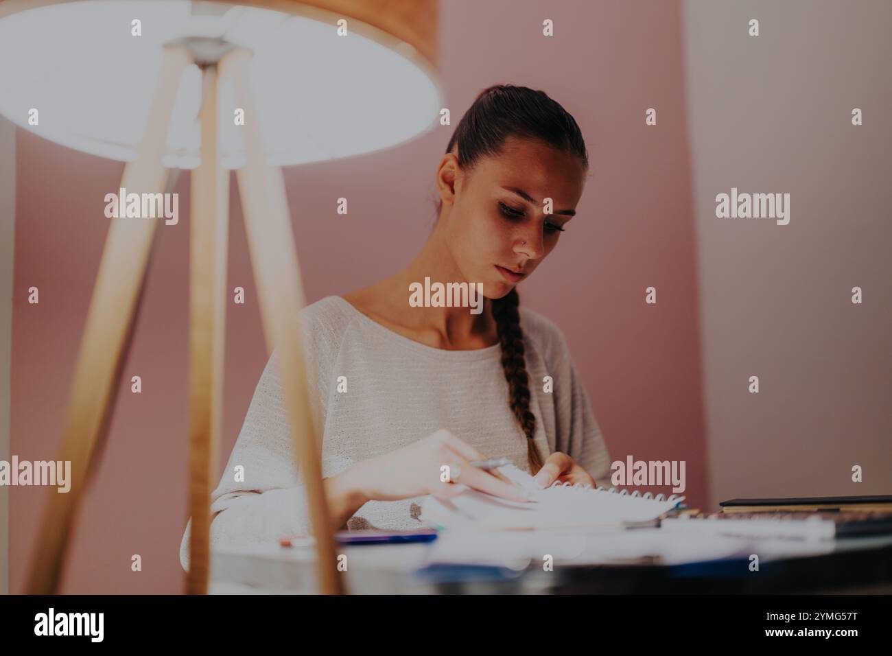 Focused college student studying at home under warm lighting Stock ...