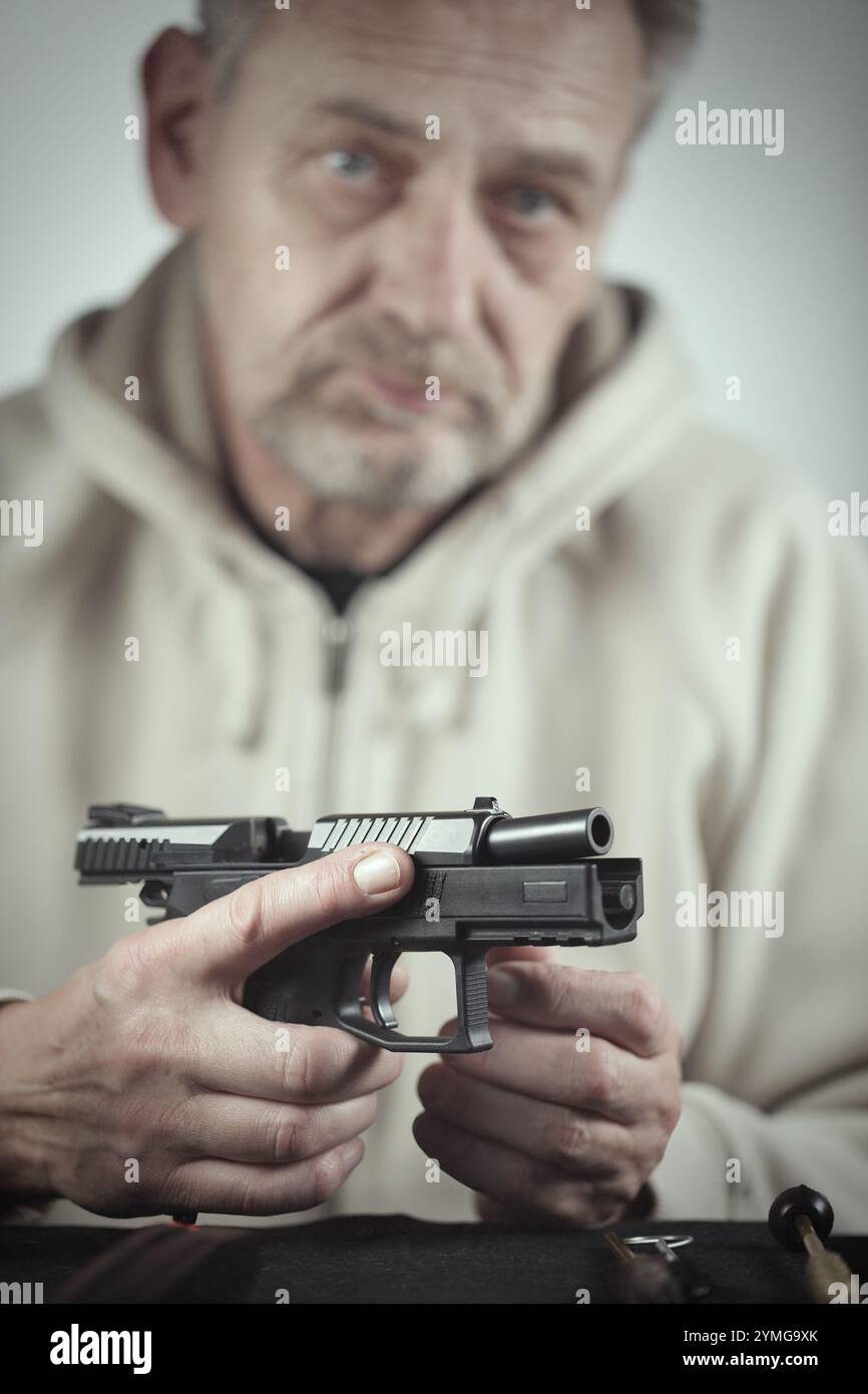 Man take care of semi automatic pistol handgun at home Stock Photo - Alamy