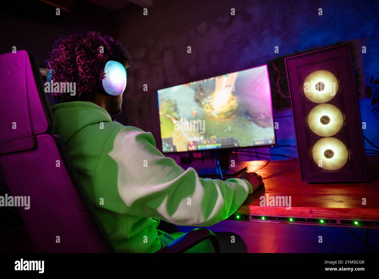 Photo of cute young guy back view screen play gamer computer purple ...