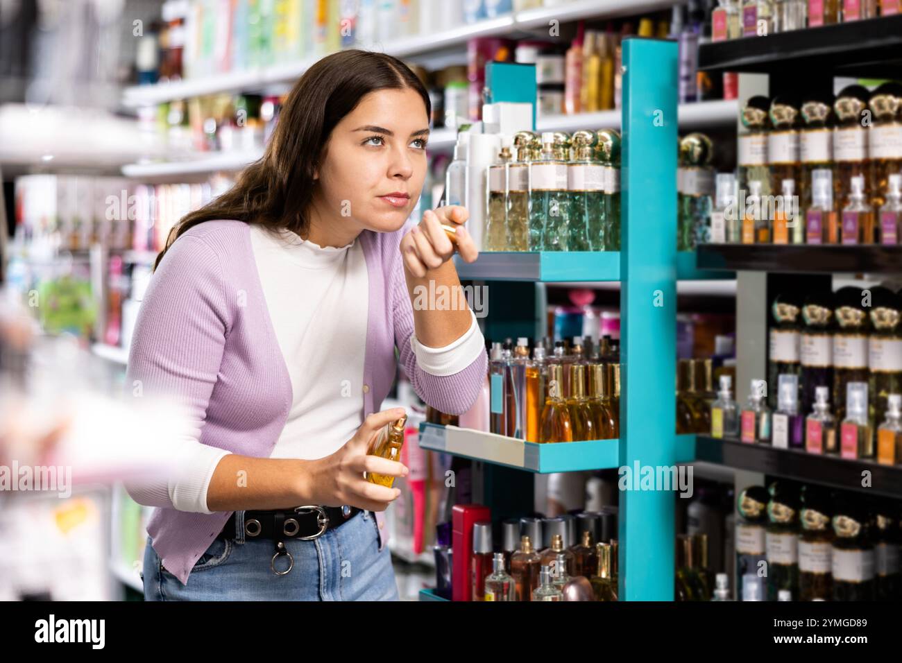 Stylish woman smelling perfume tester, choosing perfume in cosmetic ...