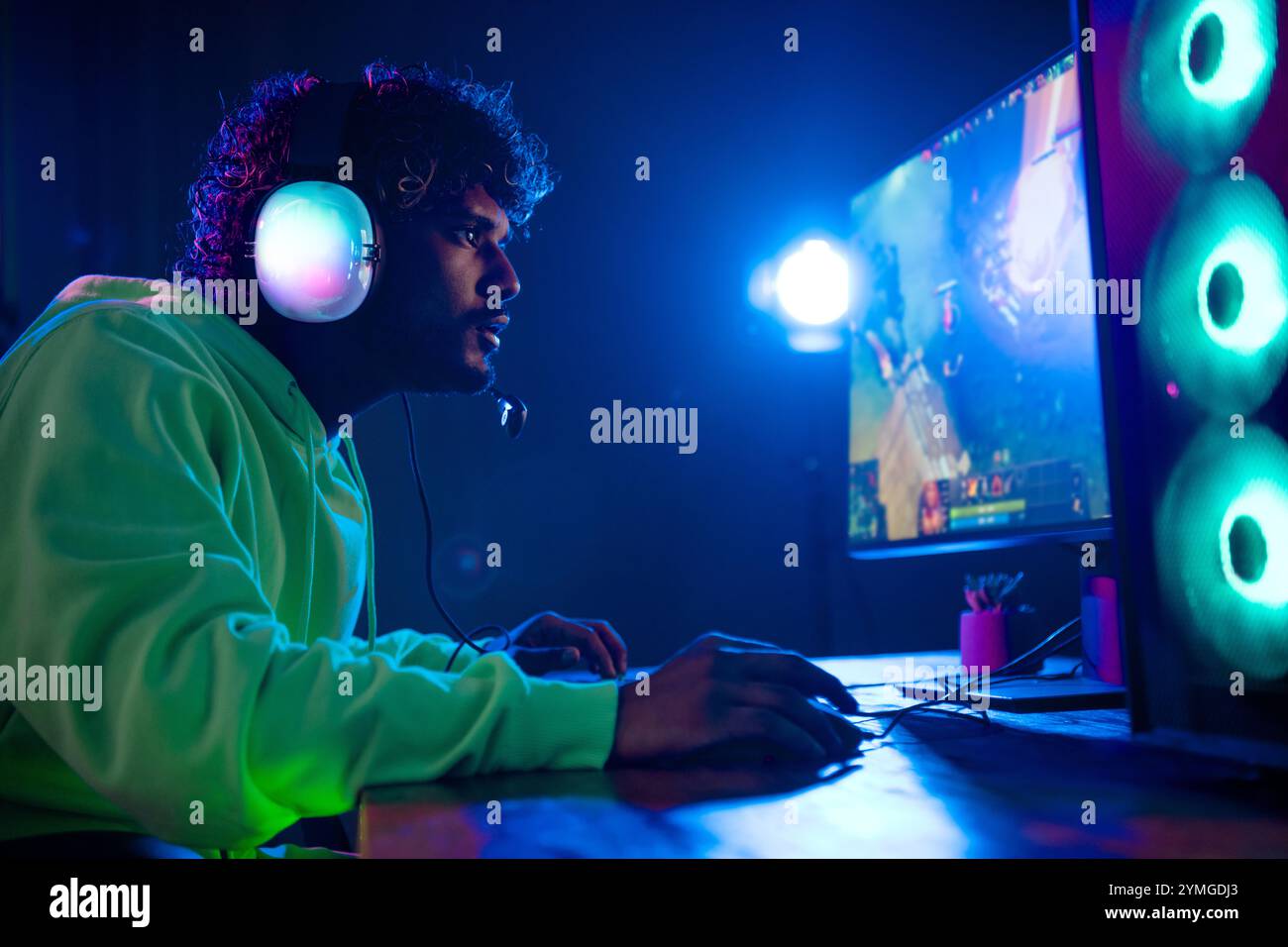 Photo of cute young guy focused look display play gamer computer purple ...