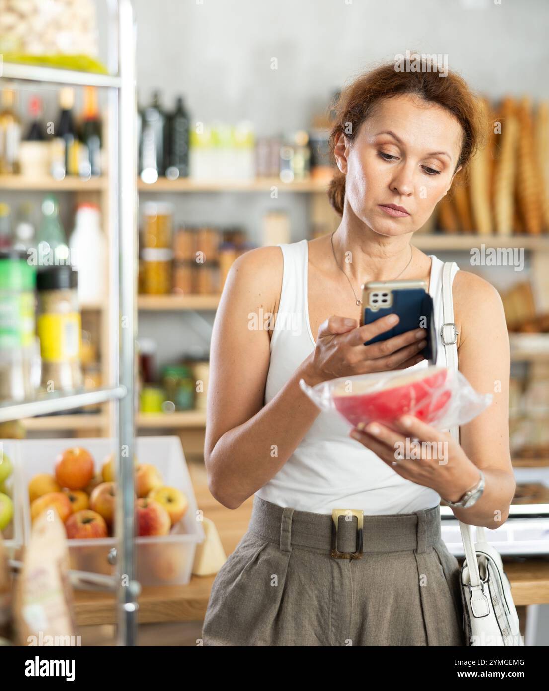 Adult woman scanning qr code of cheese Stock Photo - Alamy