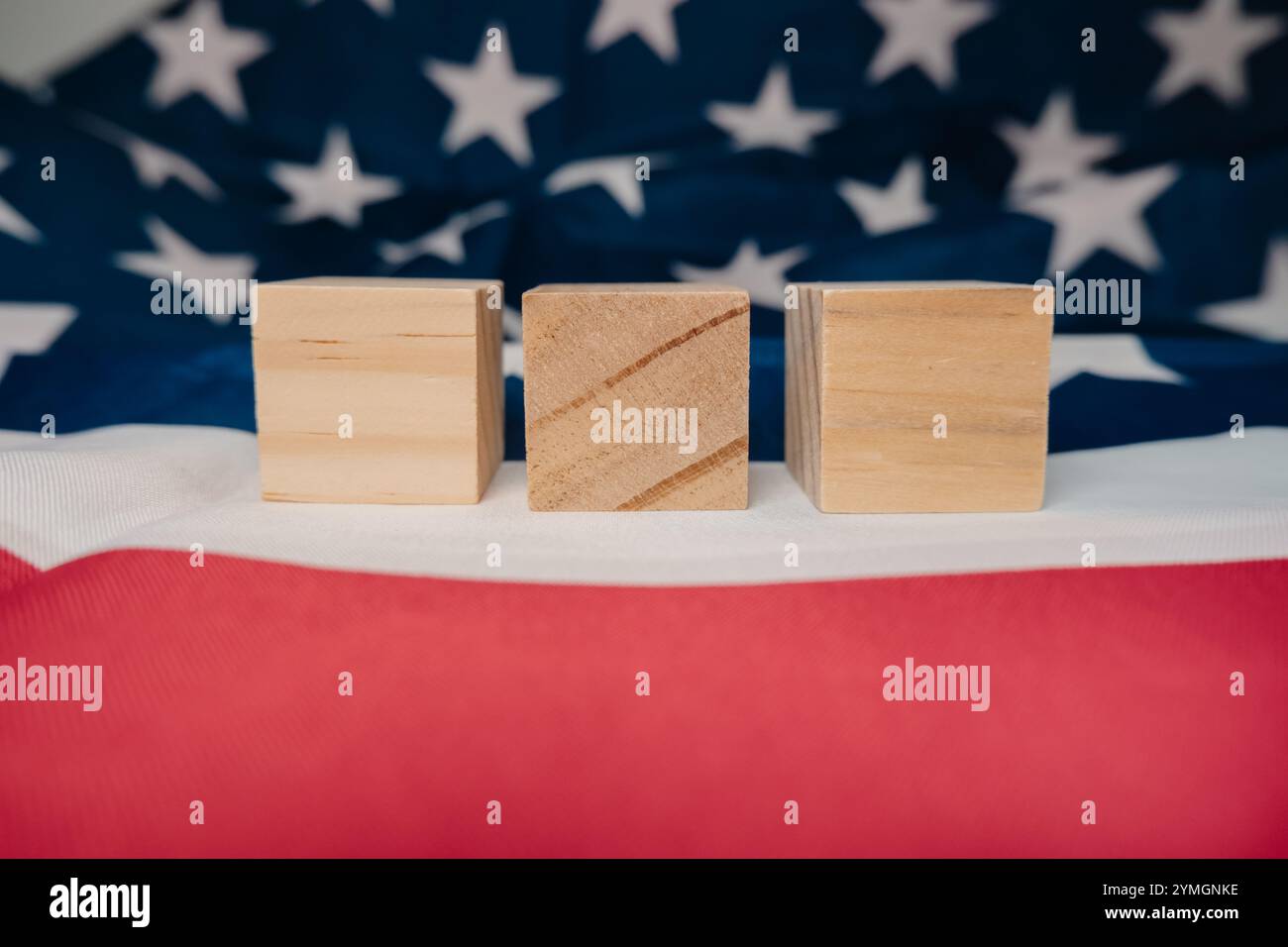 Three wooden blocks are placed on top of a red and white American flag ...