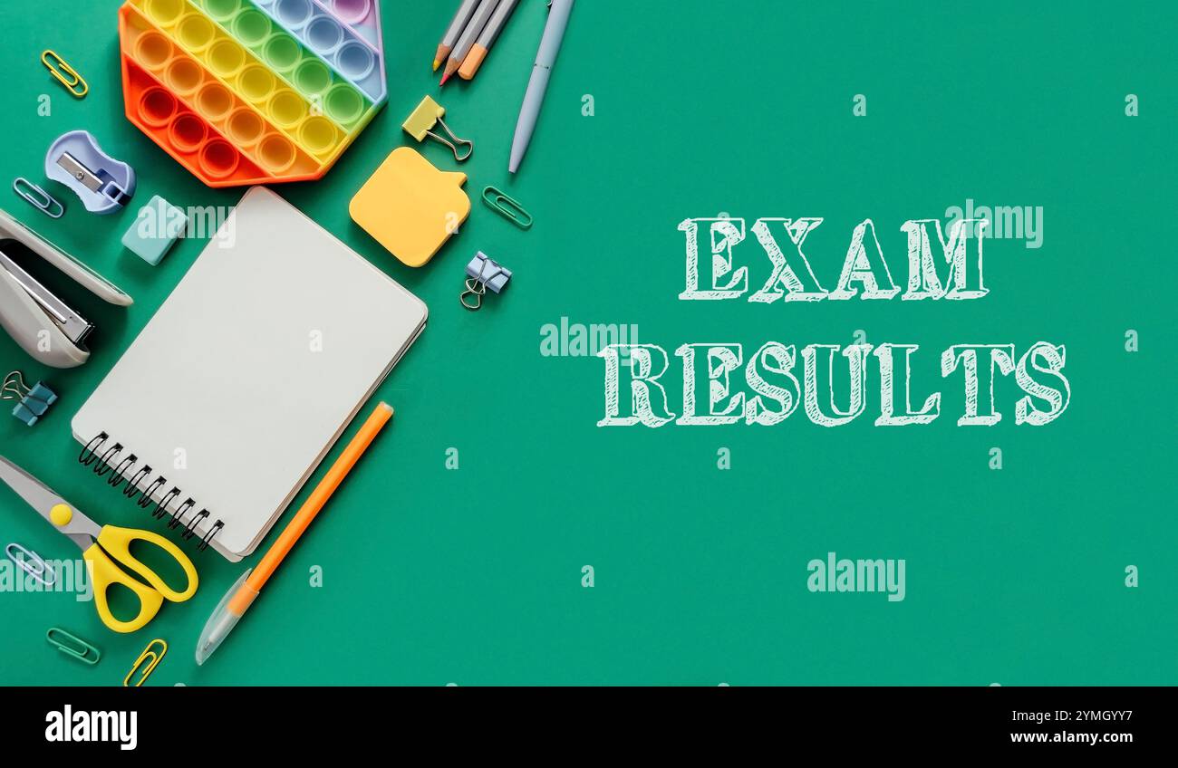 Exam results are written on a green background with a notebook, pens ...