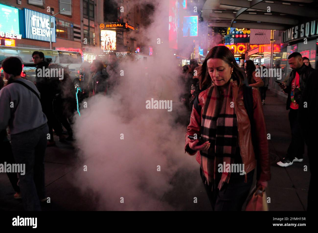 People walk past steam coming out from the ground on the street in ...