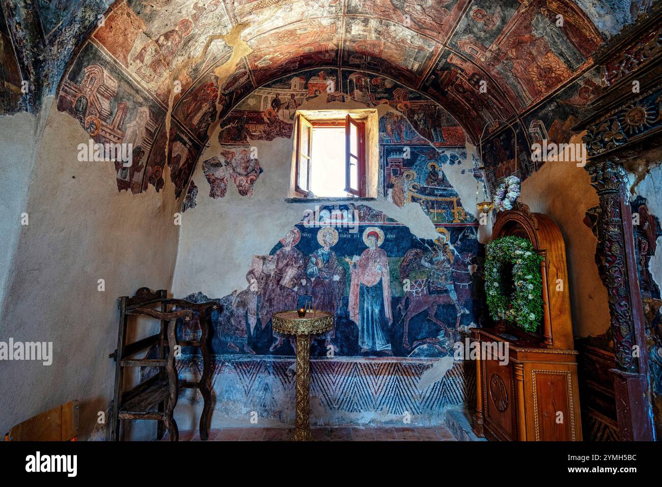 Historic frescoes and a small altar with natural light illuminating the ...