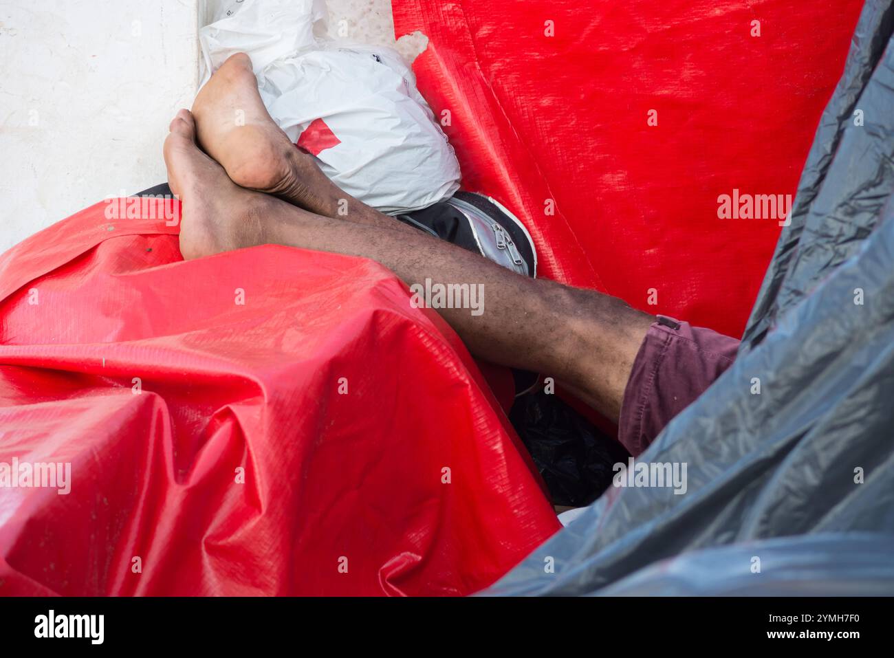 legs and feet of an unidentified person sleeping on a mattress and ...