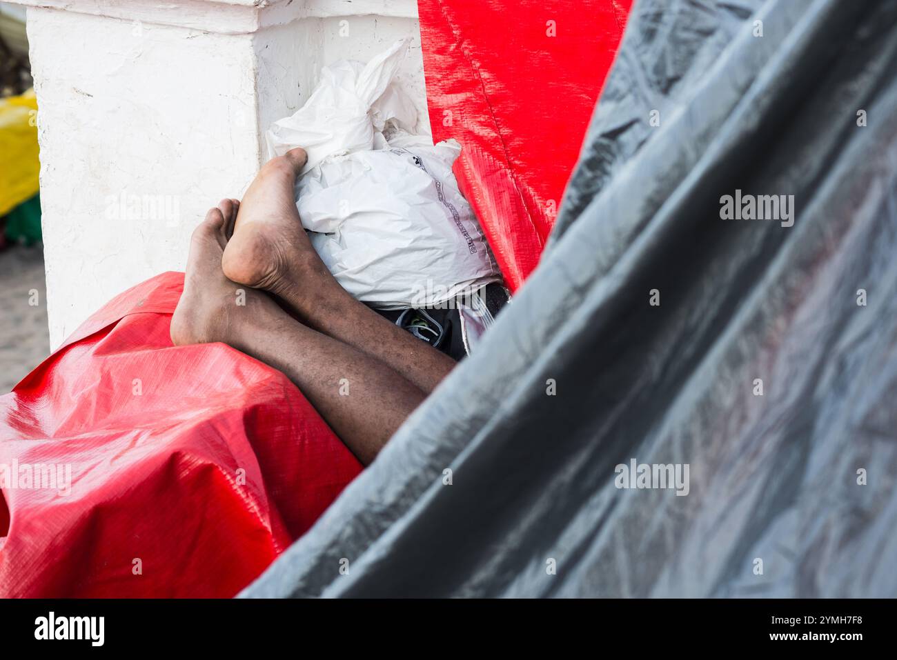 legs and feet of an unidentified person sleeping on a mattress and ...